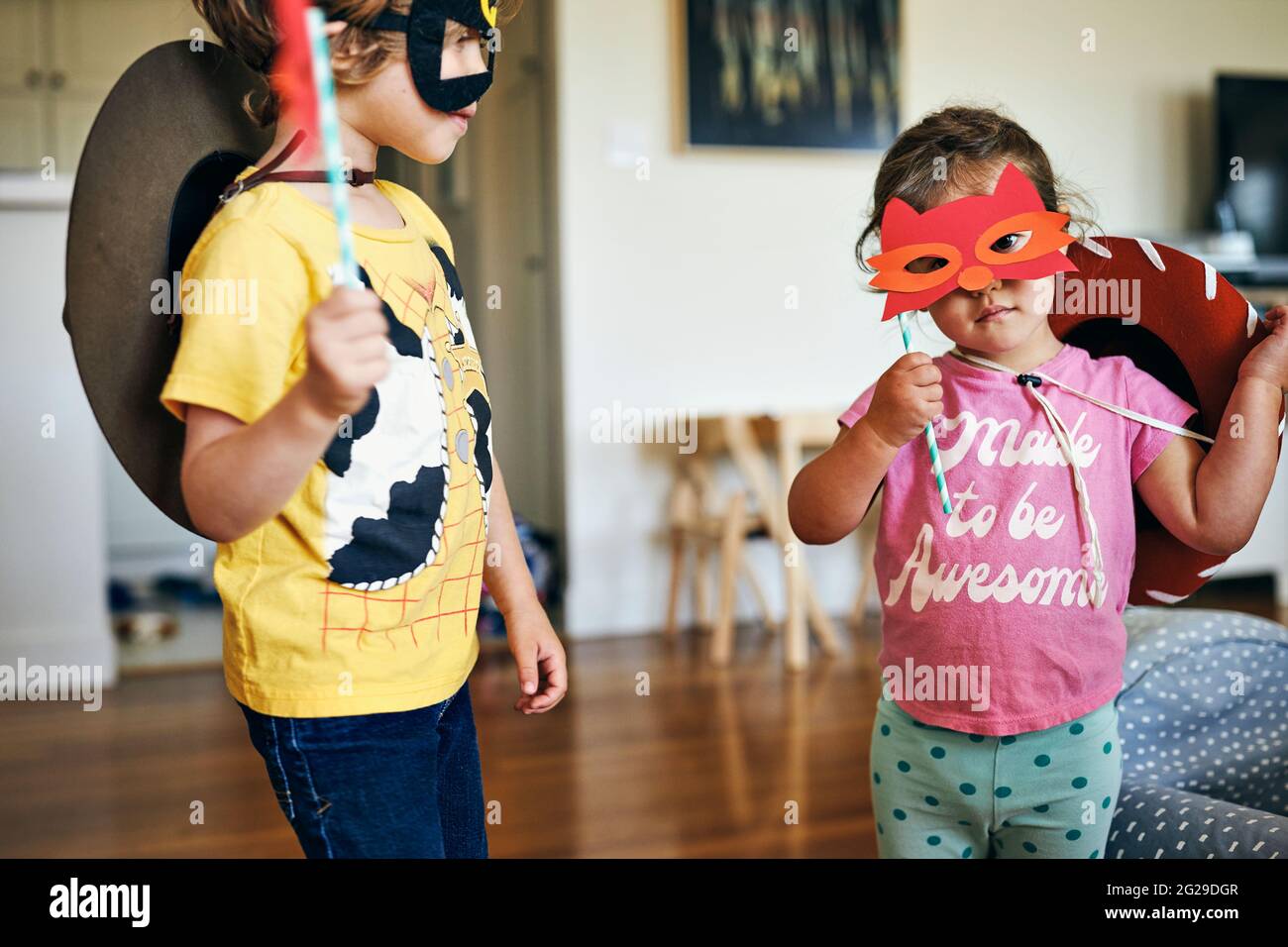 Brother and sister wearing masquerade masks at home Stock Photo - Alamy