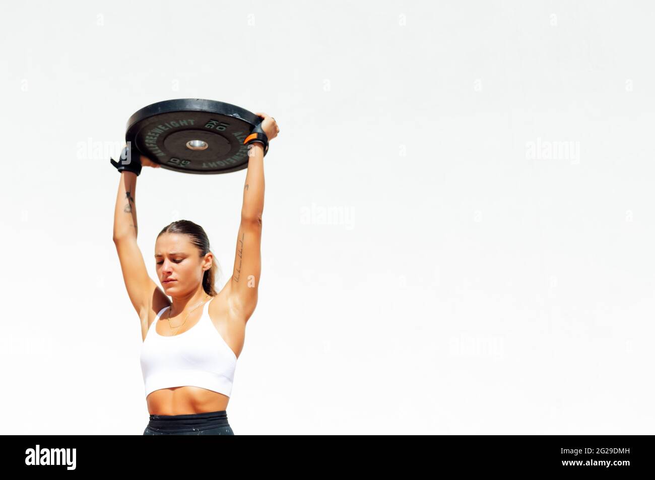 Sporty woman workout with disc barbell Stock Photo - Alamy