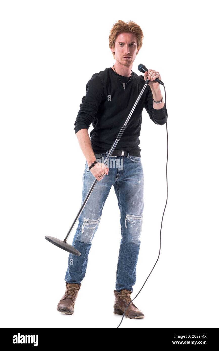Blond hair rock music singer carrying microphone with stand looking at ...