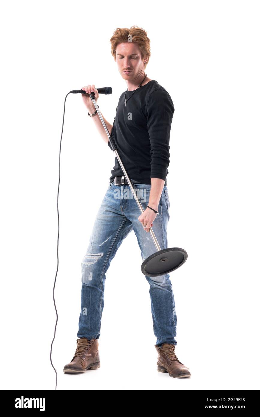 Macho handsome rocker male singer carrying microphone with stand ...