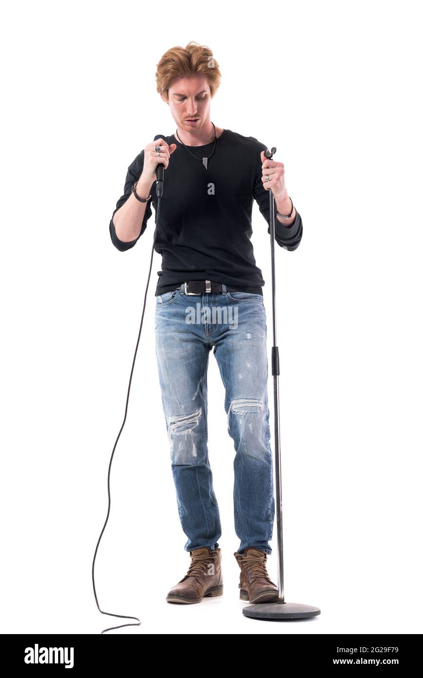 Young handsome rocker taking out microphone from its stand. Full body ...