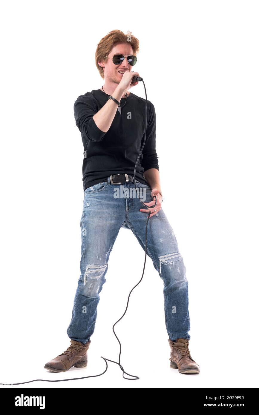 Handsome young singer with sunglasses smiling and holding microphone ...