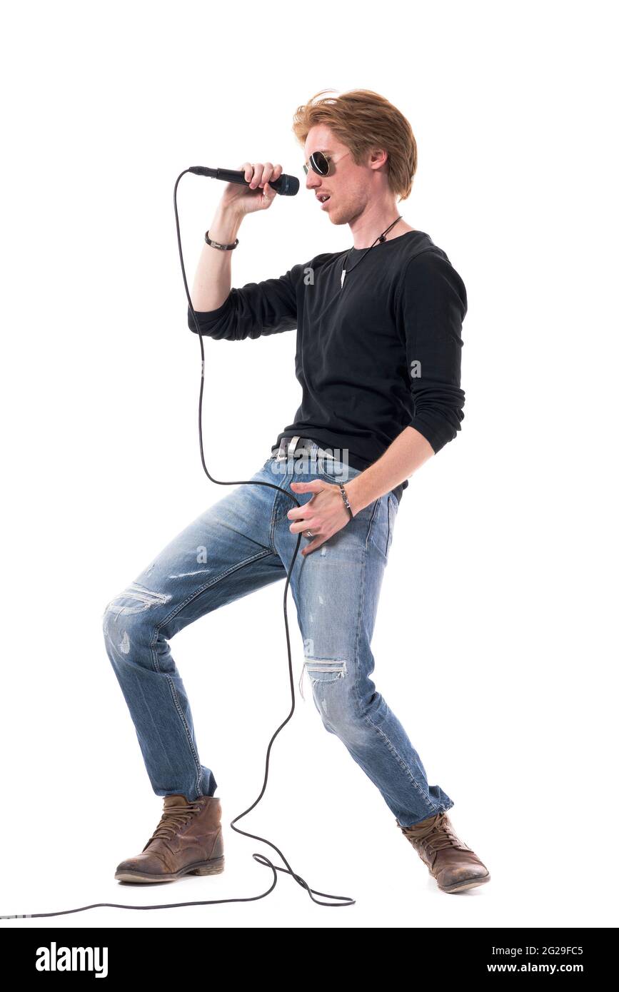 Side view of passionate rocker singing on microphone bending backwards ...