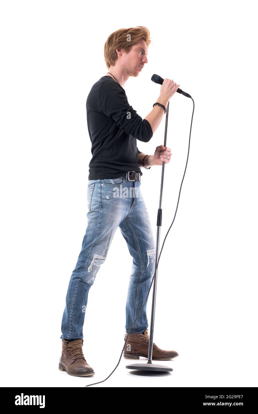 Side view of rock music singer singing on microphone. Full body length ...
