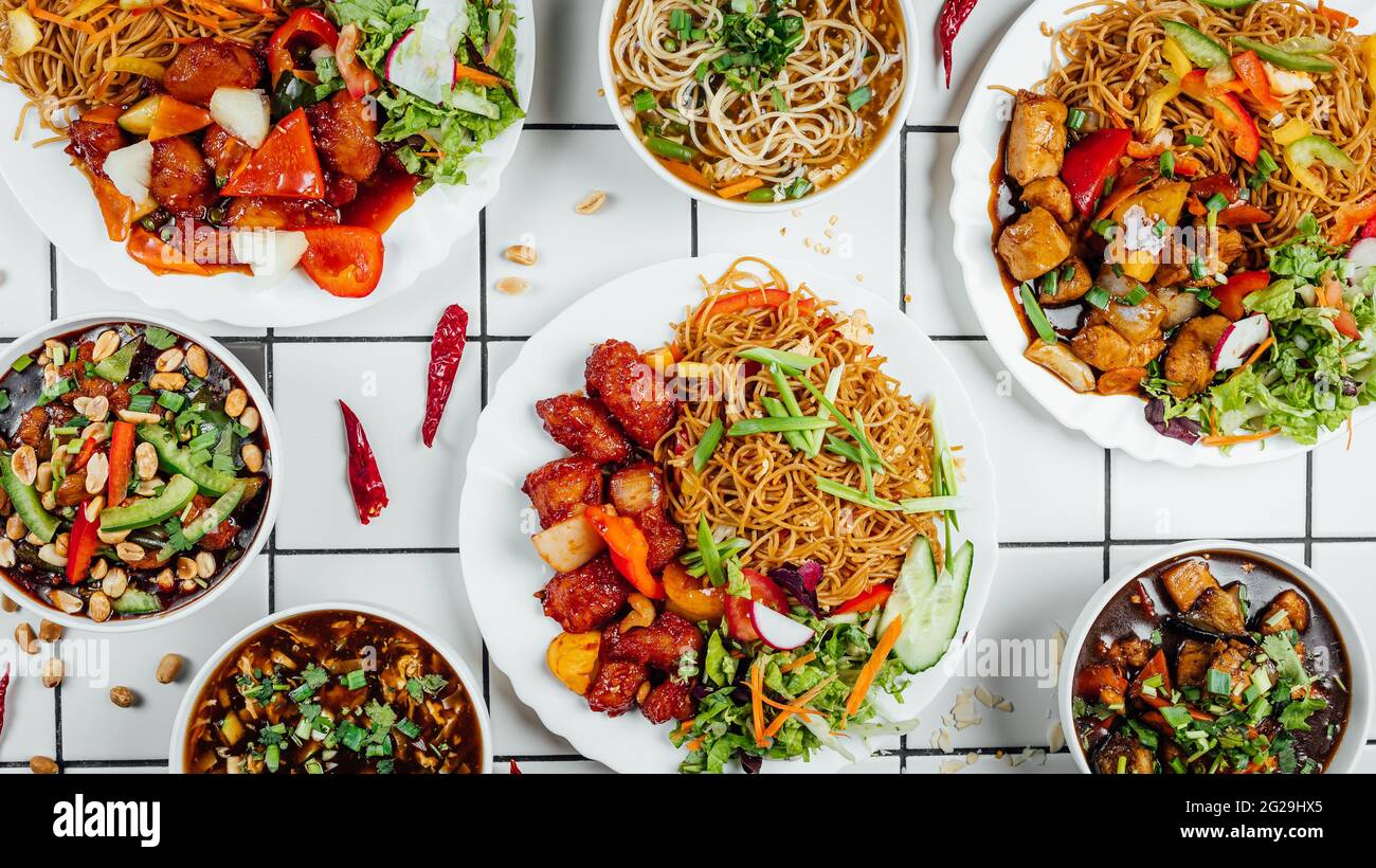 Top view of a variety of food including noodles, spicy chicken wings ...