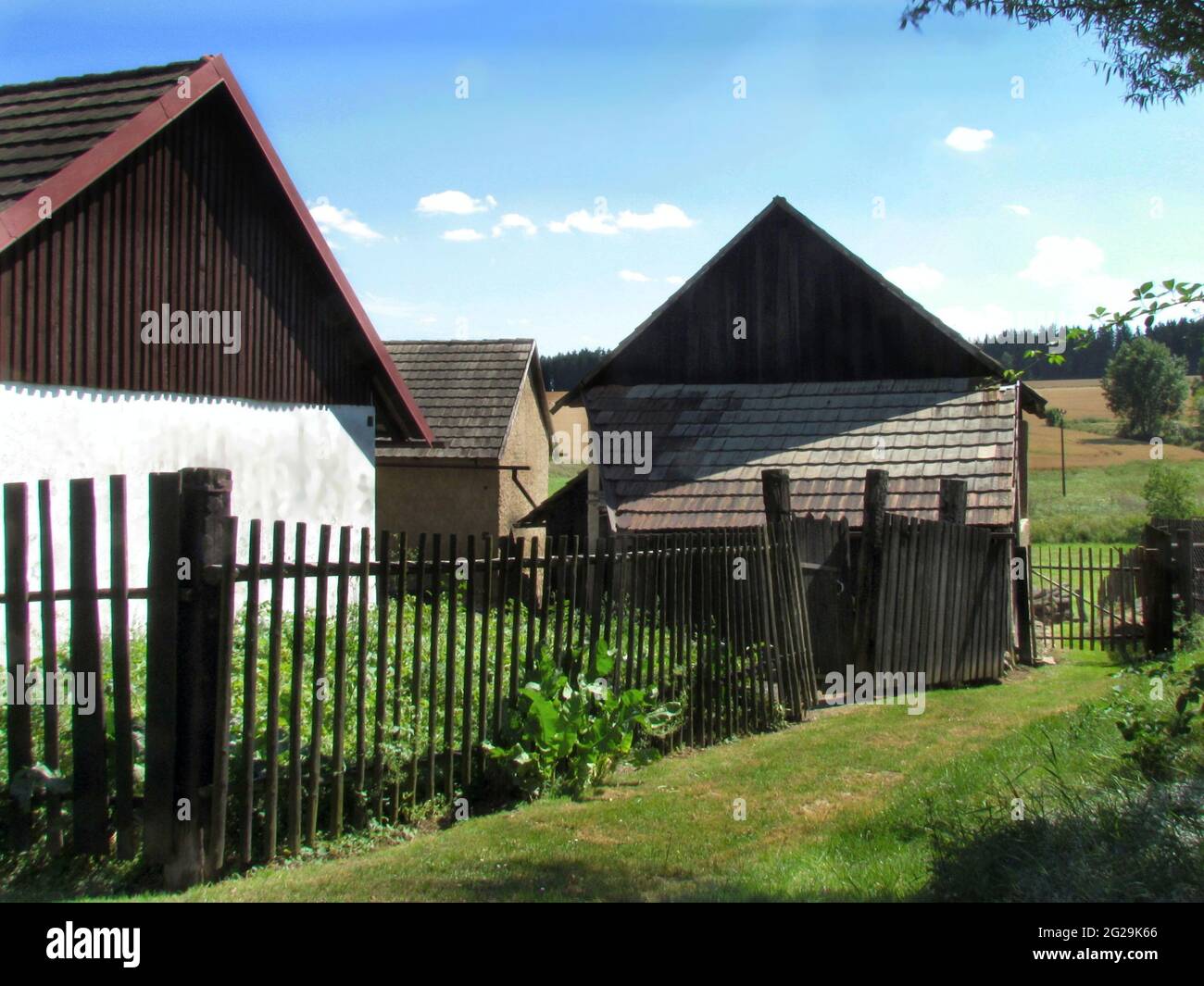 Typical rural landscape with barn and farmhouse, wood fence in Czech ...