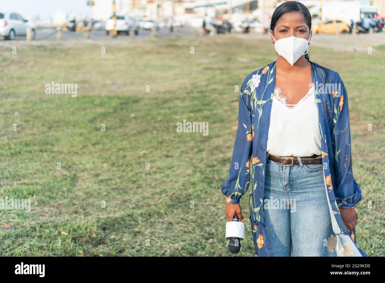 Journalist with face mask and microphone in the street Stock Photo - Alamy