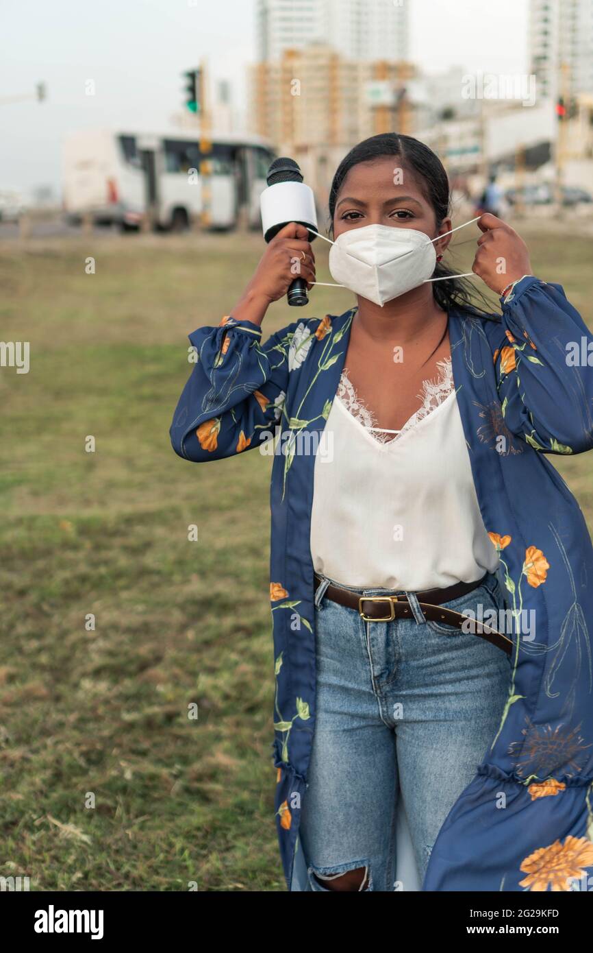 African American journalist putting on face mask while on the street in ...