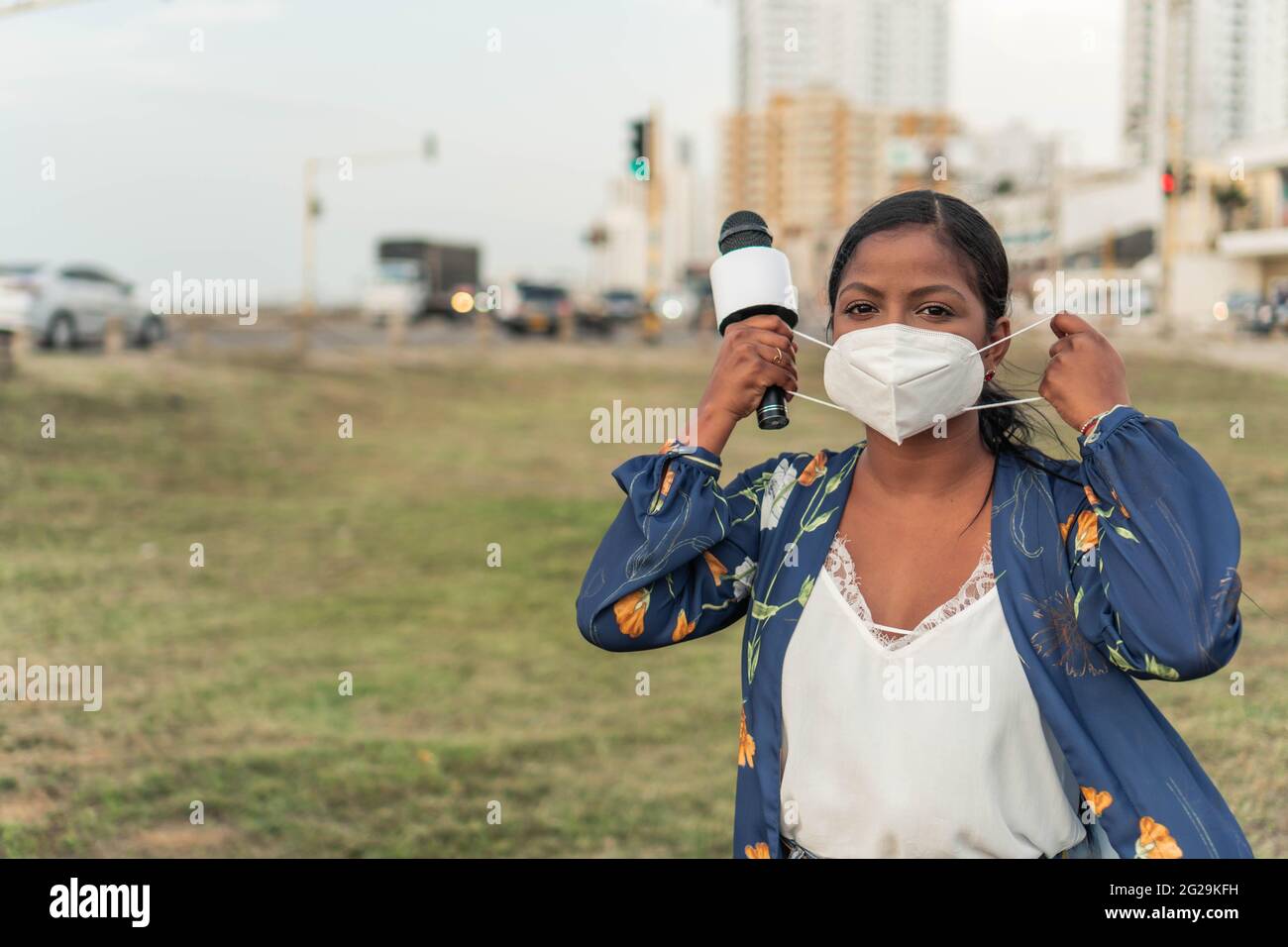 Black journalist putting on face mask while on the street in the city ...