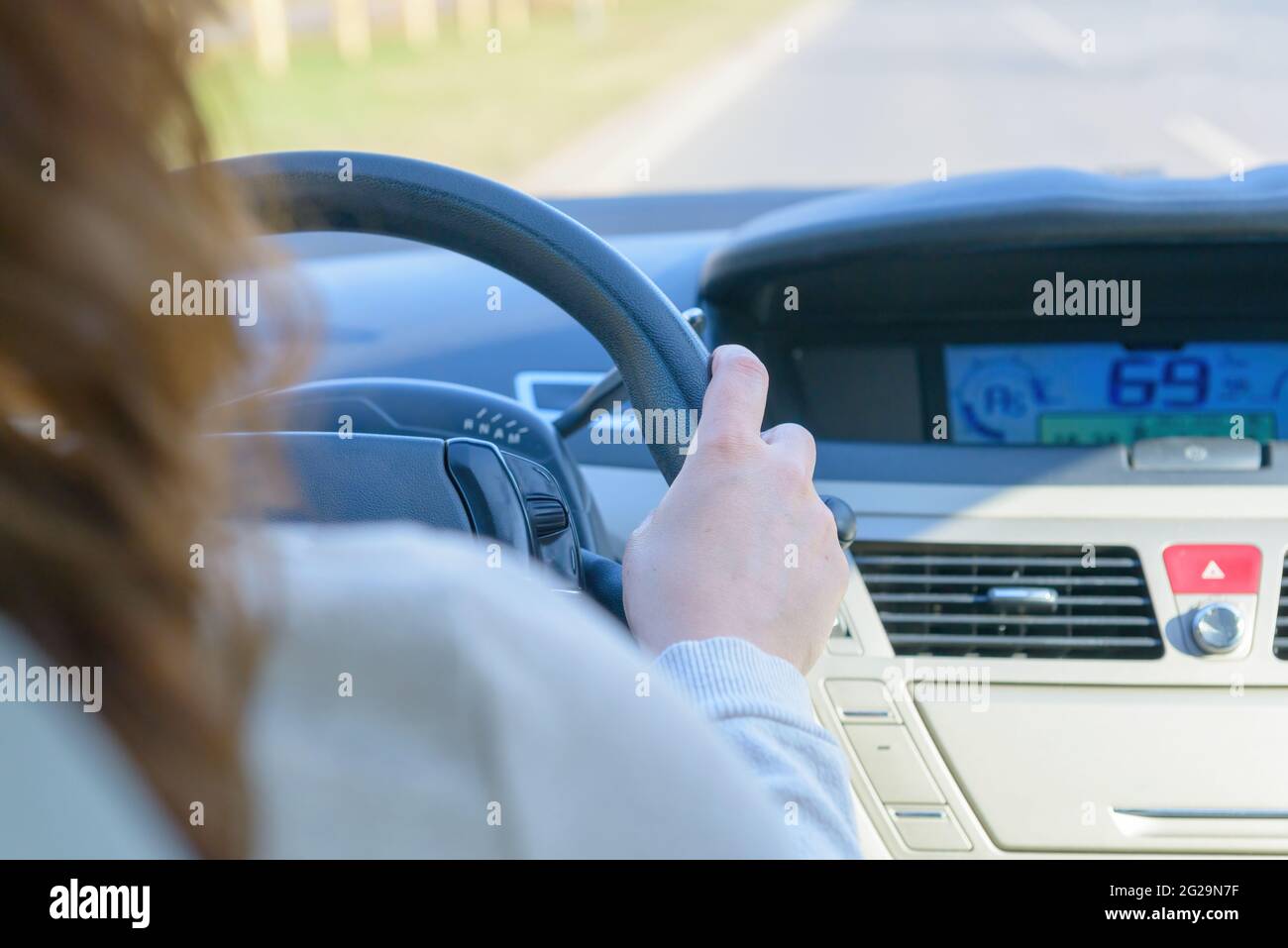 Woman driving a car, close up of her hand at the steerin wheel. View ...