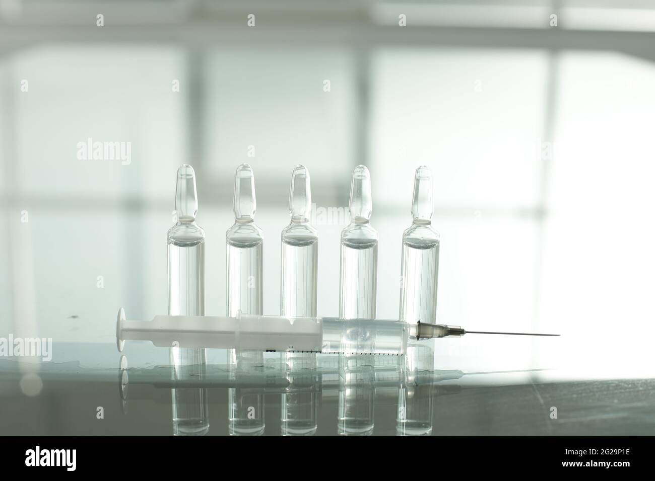 Medicine vials and syringe on glass table in hospital room Stock Photo ...