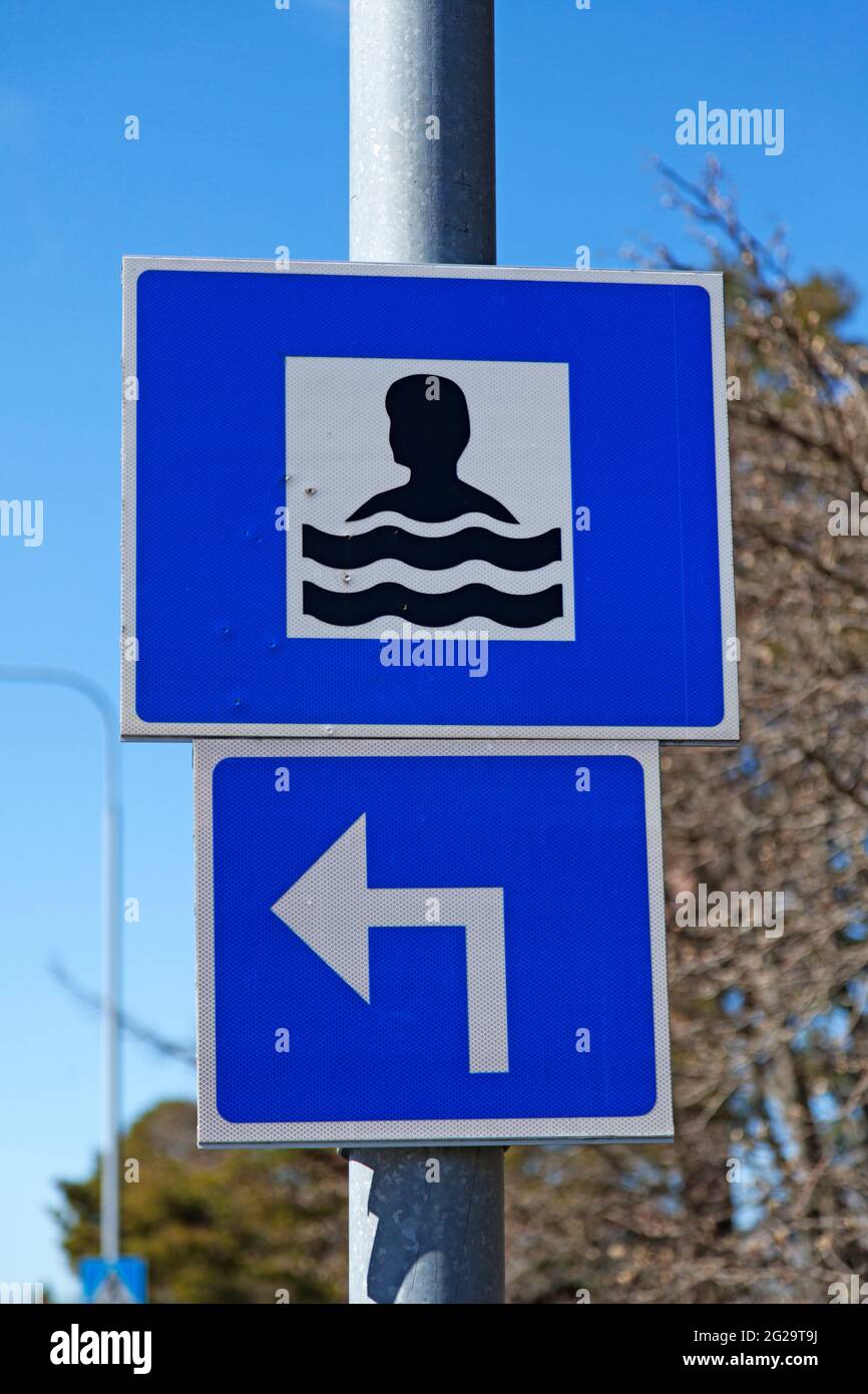 road sign that shows in which direction you can find a bathing place ...
