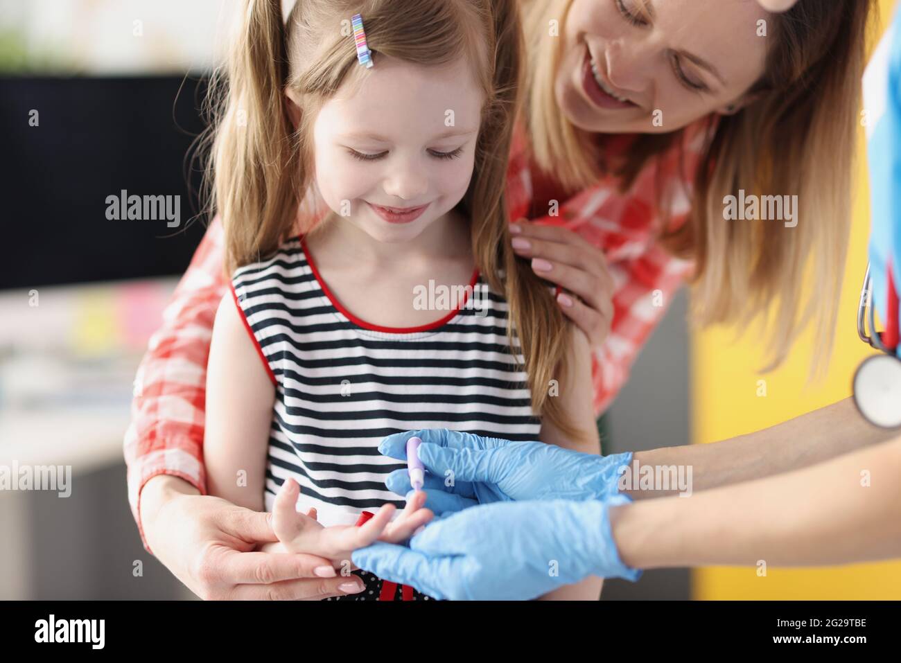 Doctor laboratory assistant taking blood of little girl using lancet in ...