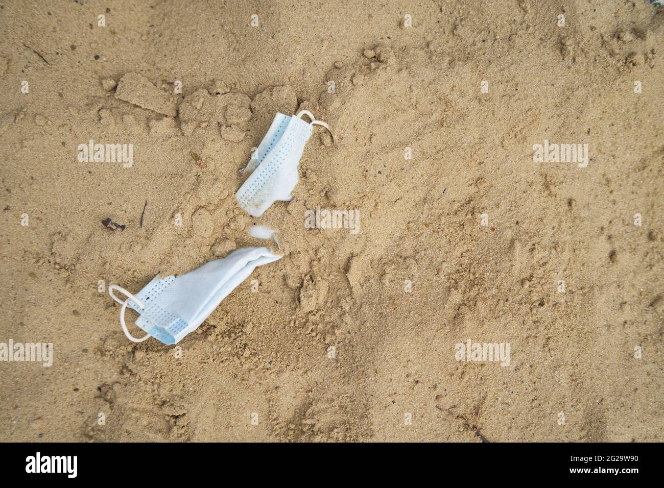 Disposable face mask in the sand on the beach, quarantine and sea ...