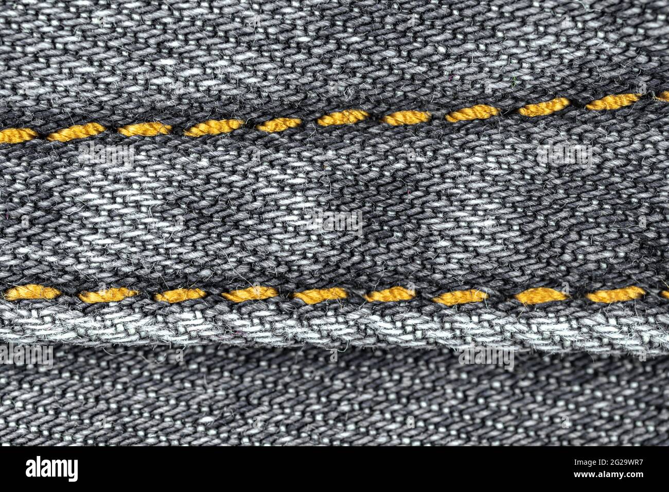 Stitching on the black denim jean fabric texture background close up ...