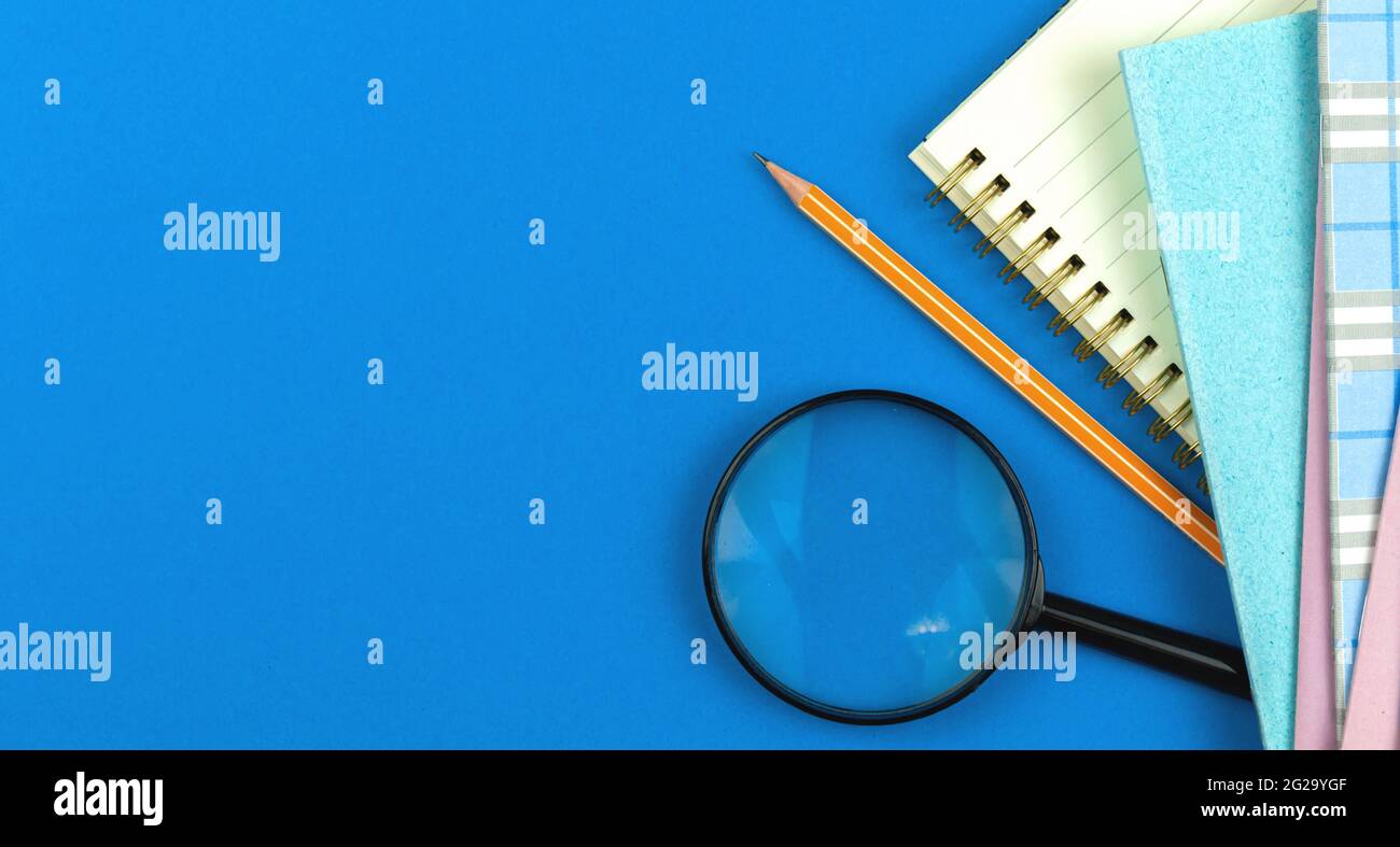 School flat lay composition with notebooks pencil and magnifying glass ...