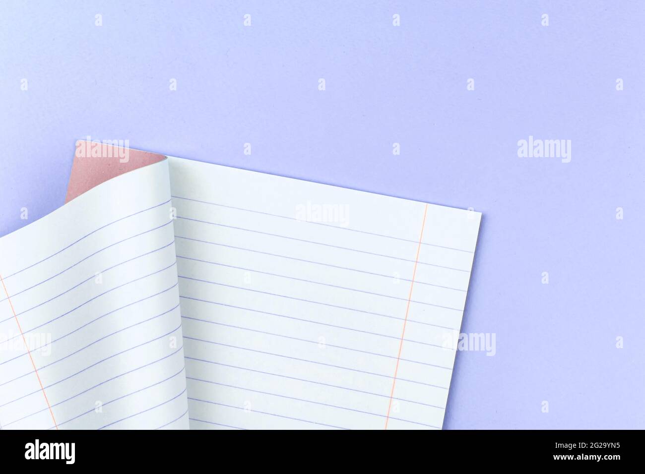 Opened lined notebook for school on a pastel purple background of ...