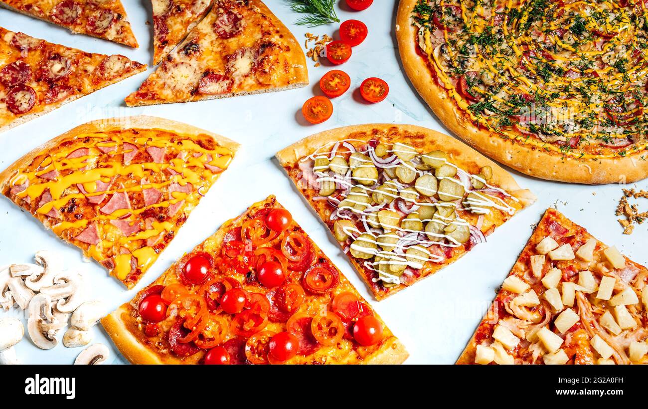 Various types of pizza slices on a white surface Stock Photo - Alamy