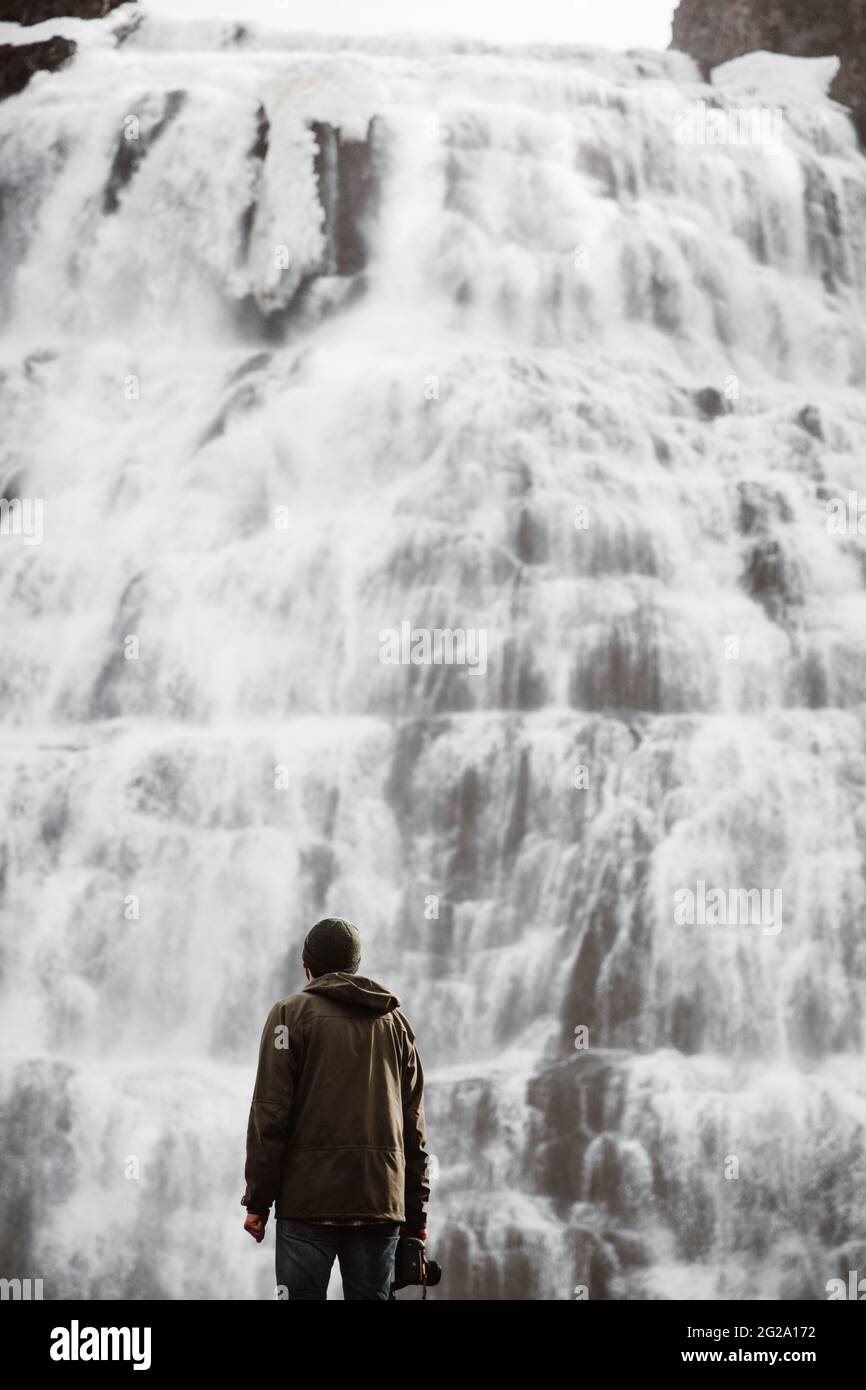 Back view of man with photo camera standing on background of amazing ...