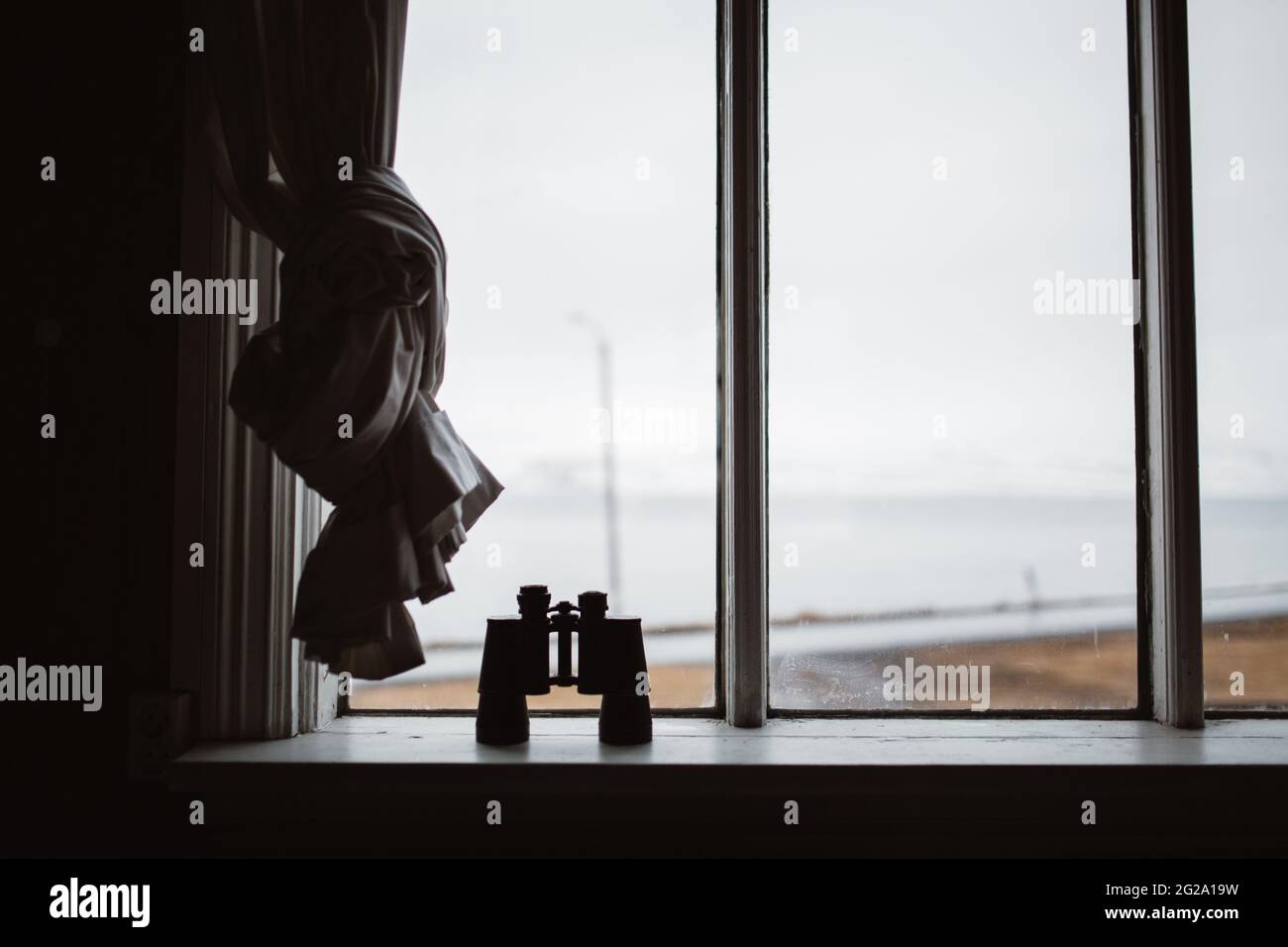 Binoculars on white windowsill Stock Photo - Alamy