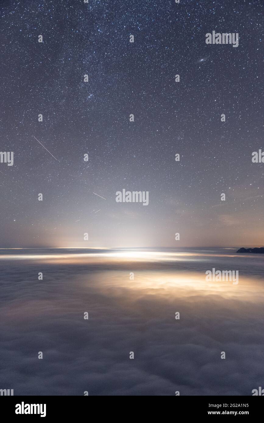 starry sky over clouds at night Stock Photo - Alamy