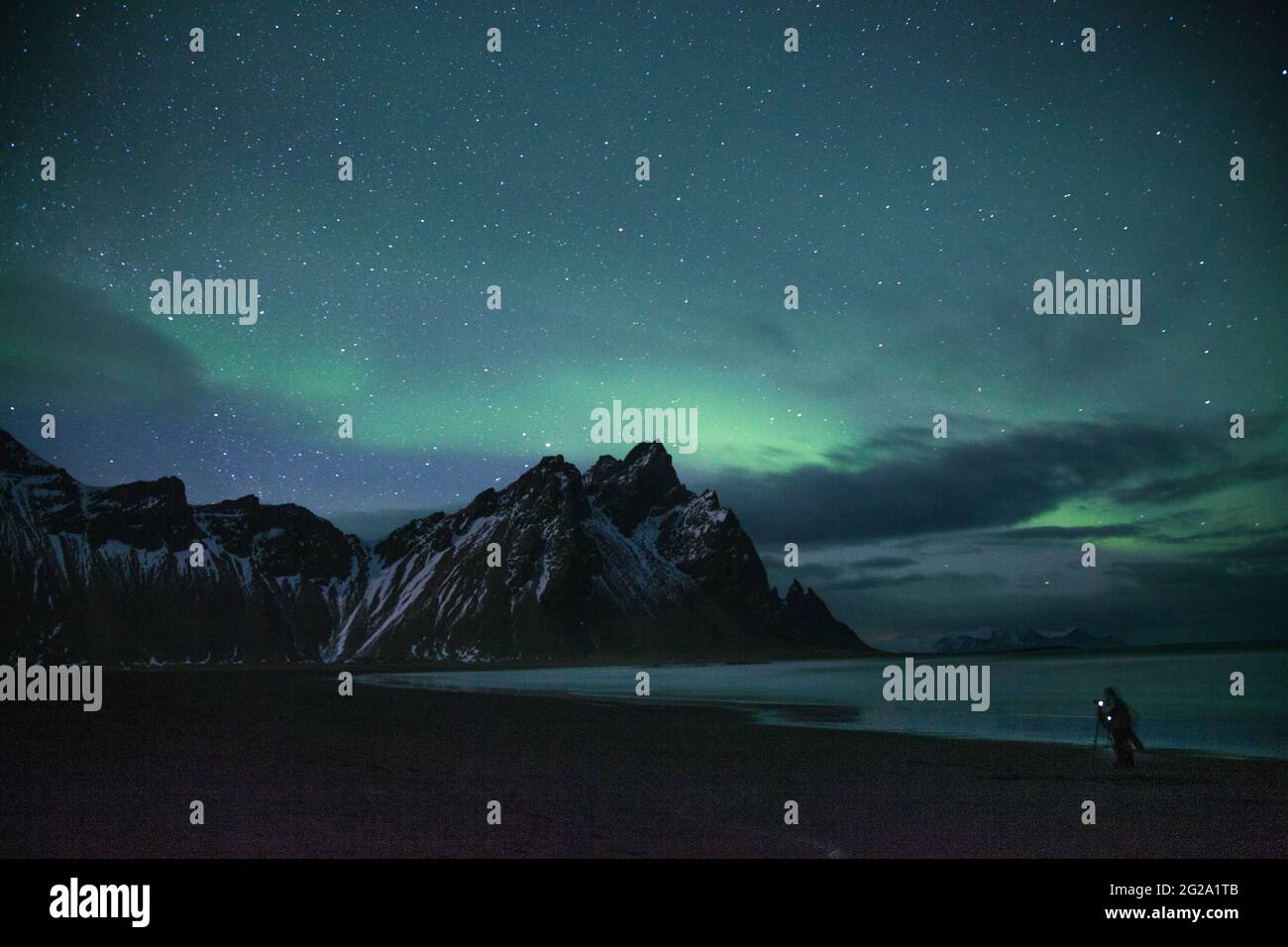 Breathtaking landscape of calm seashore with peaky snowy mountains ...