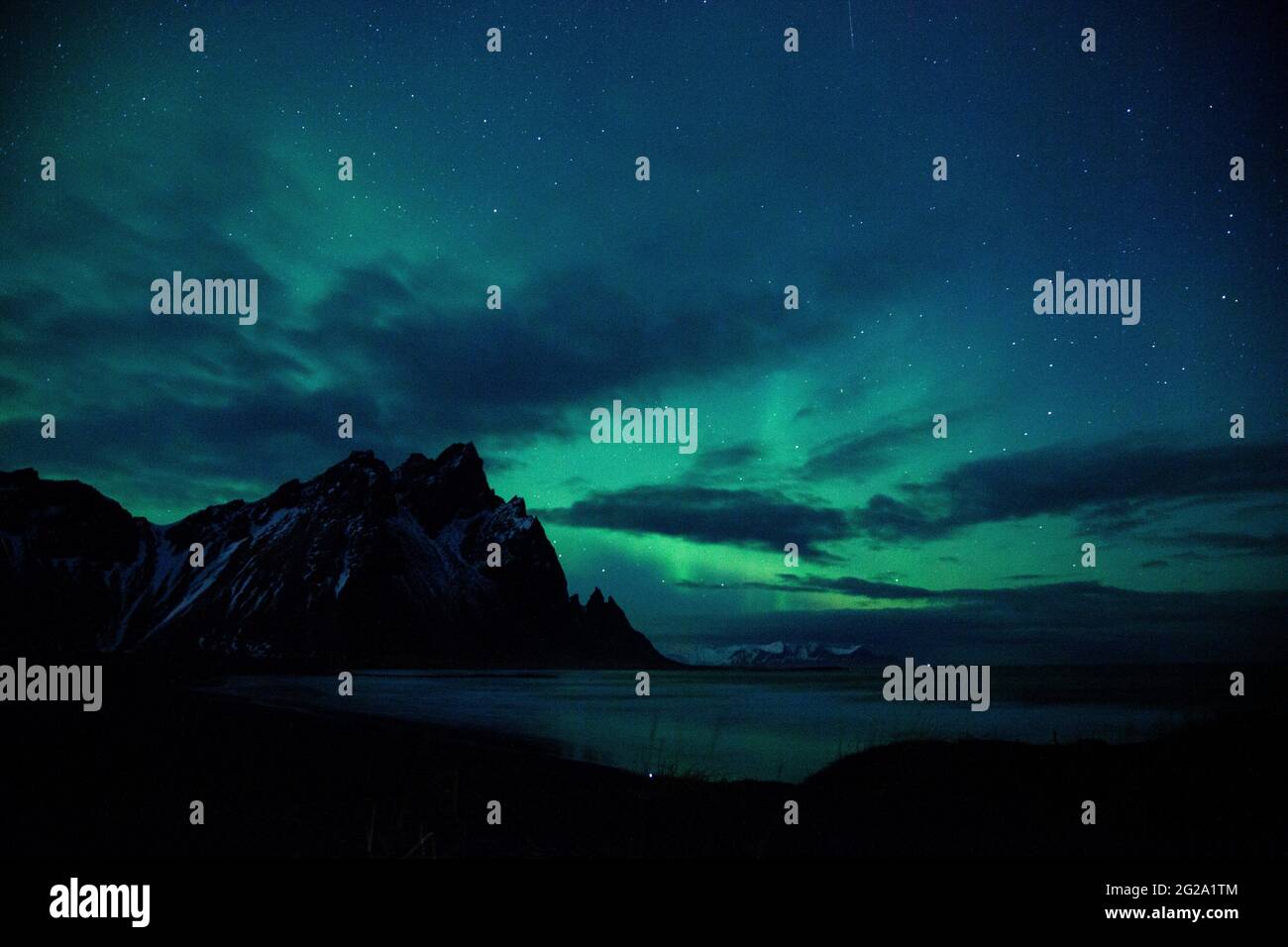Breathtaking landscape of calm seashore with peaky snowy mountains ...