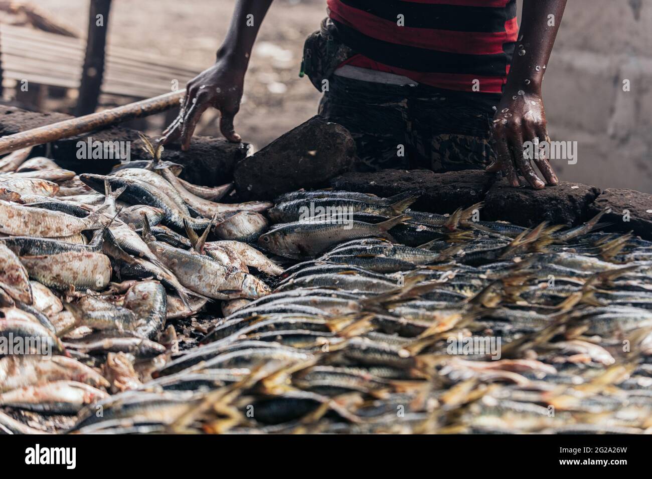 Crop ethnic man with hands covered in scales standing by stone parapet ...