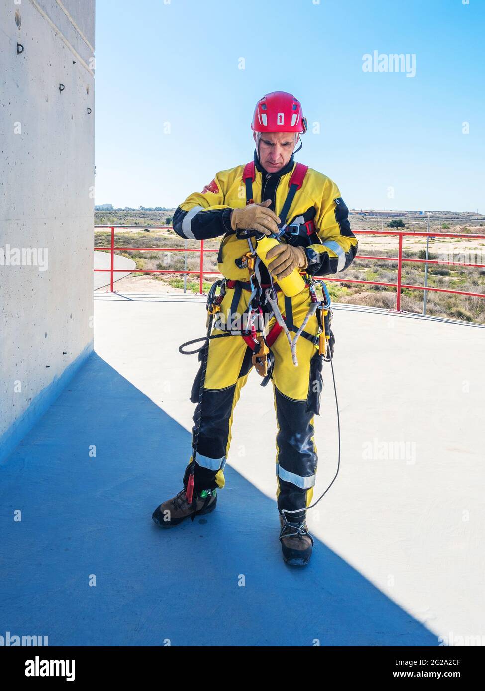 Professional fireman climber in uniform ready for climbing hanging on ...