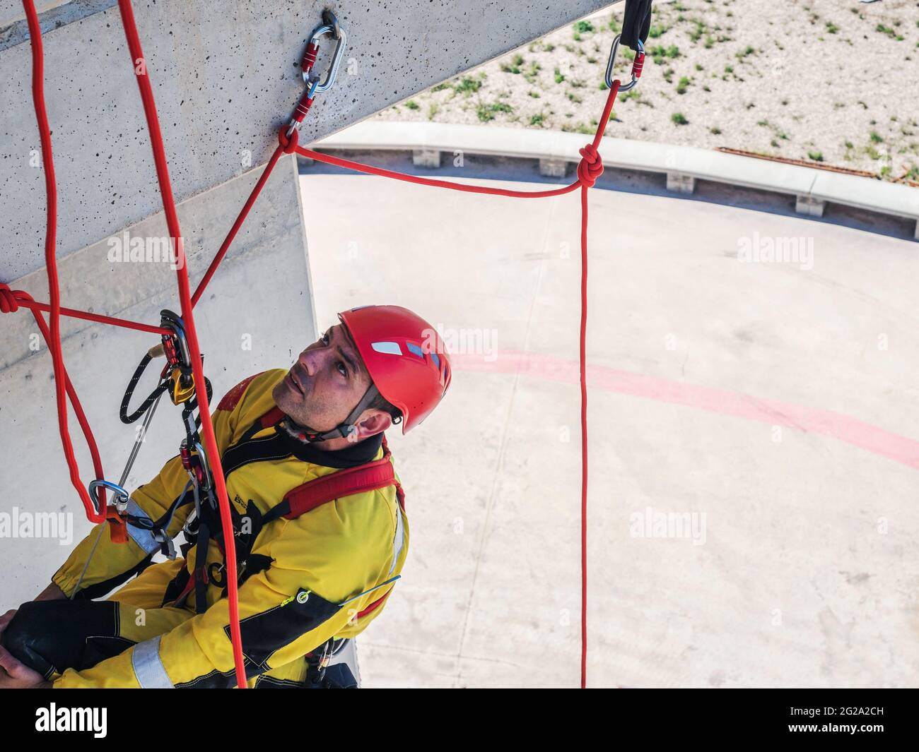 Professional fireman climber in uniform hanging on ropes while training ...