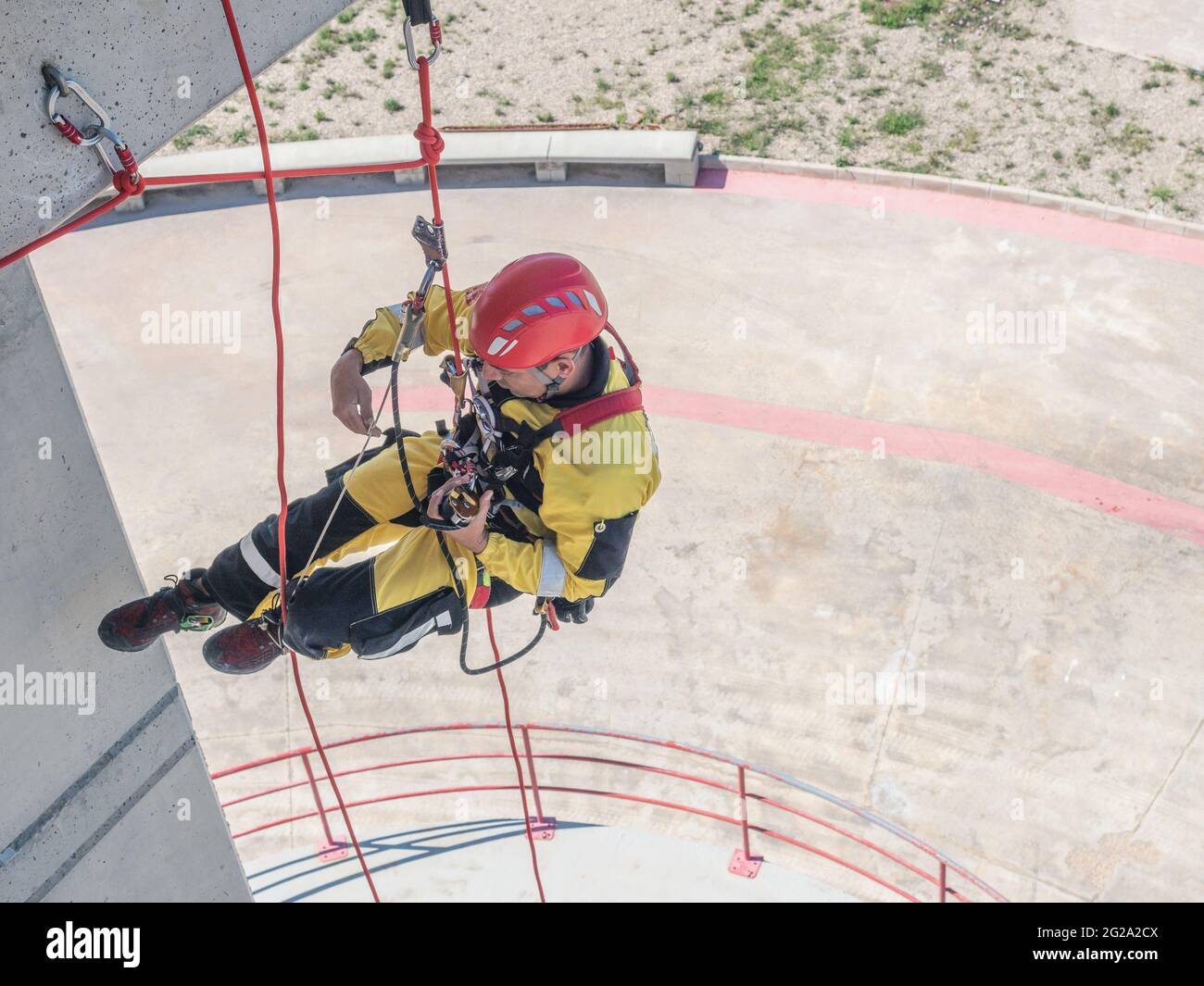 Professional fireman climber in uniform hanging on ropes while training ...