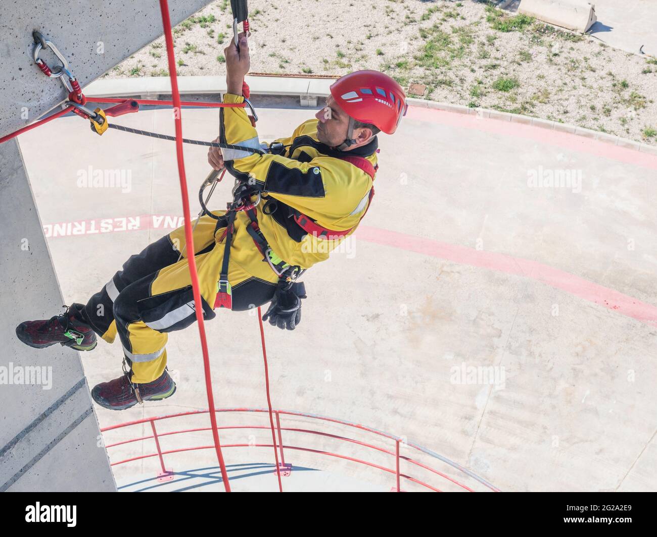 Professional fireman climber in uniform hanging on ropes while training ...