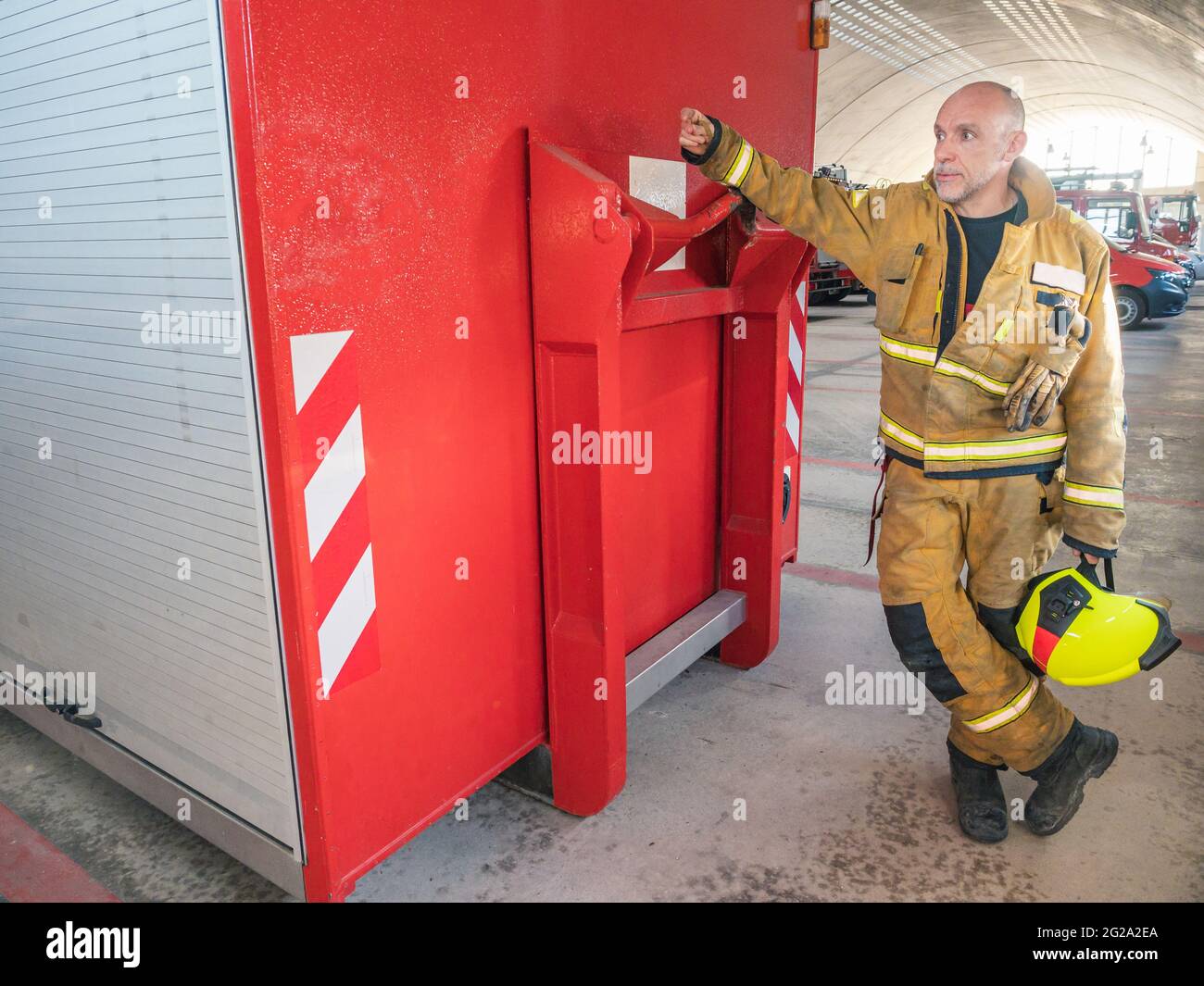 Professional fireman standing near container and looking away Stock ...