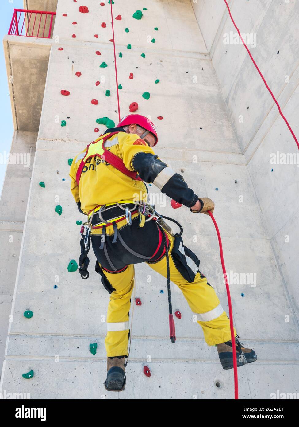 Professional fireman climber in uniform hanging on ropes while training ...