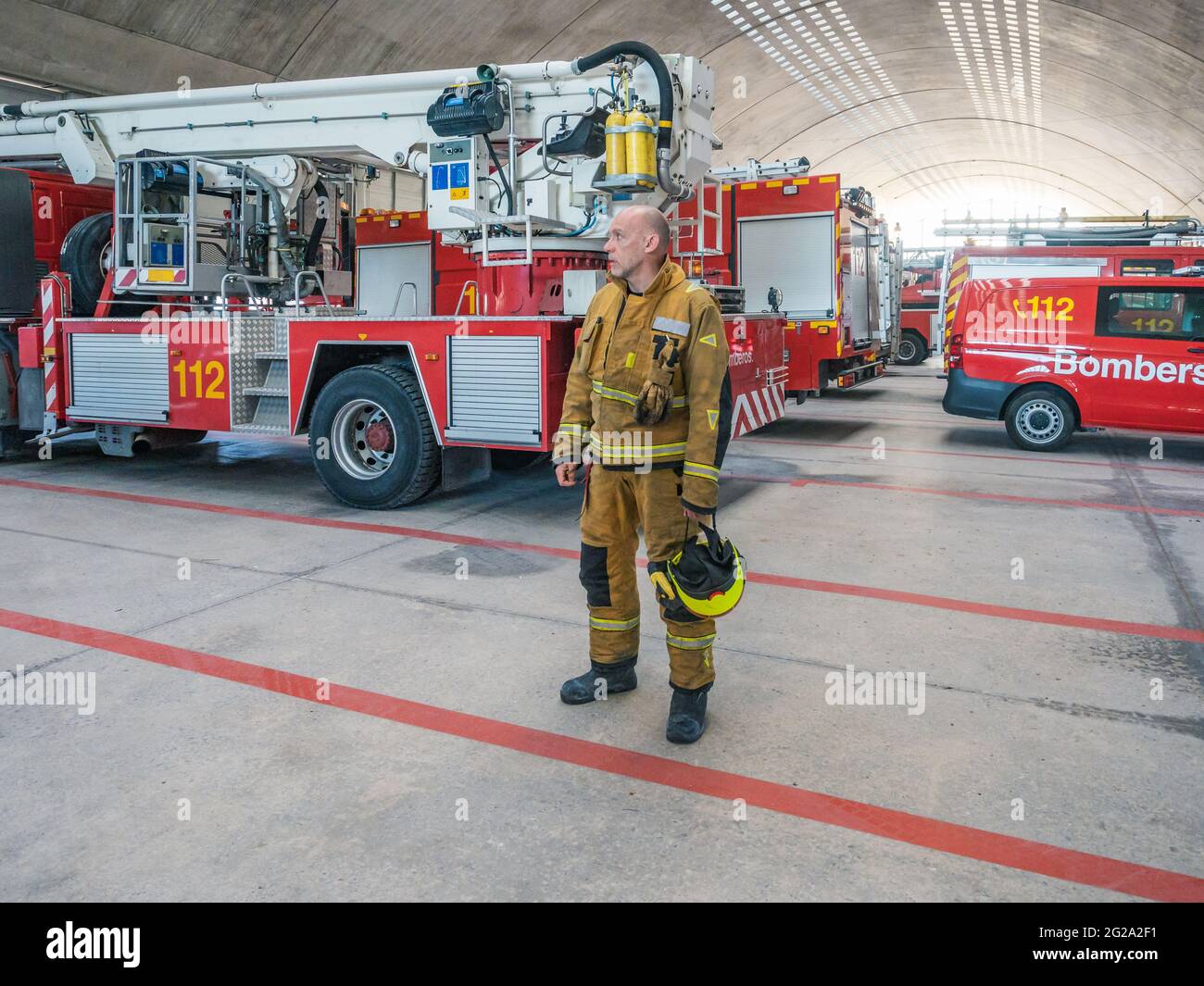 Professional fireman standing near fire truck and looking away Stock ...
