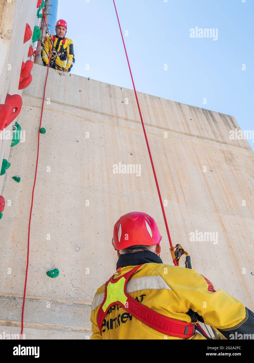 Professional fireman climber in uniform hanging on ropes while training ...