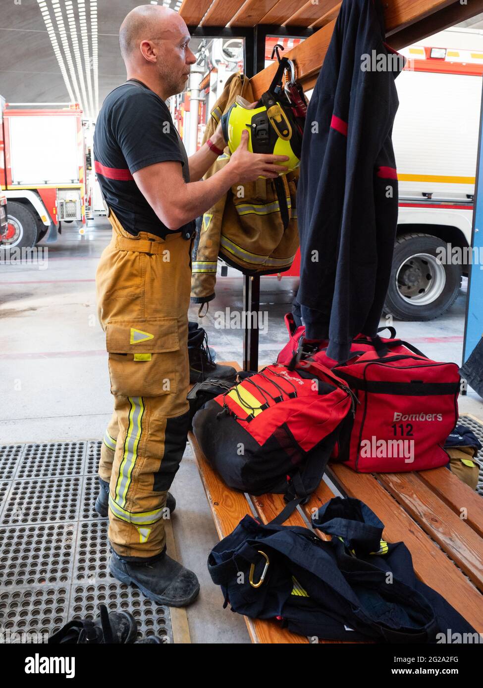 Professional fireman getting ready near fire truck and looking away ...