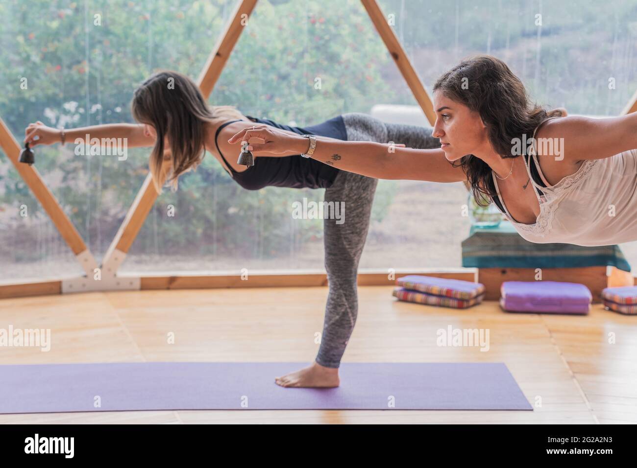Side view of calm balanced women performing yoga and standing in ...