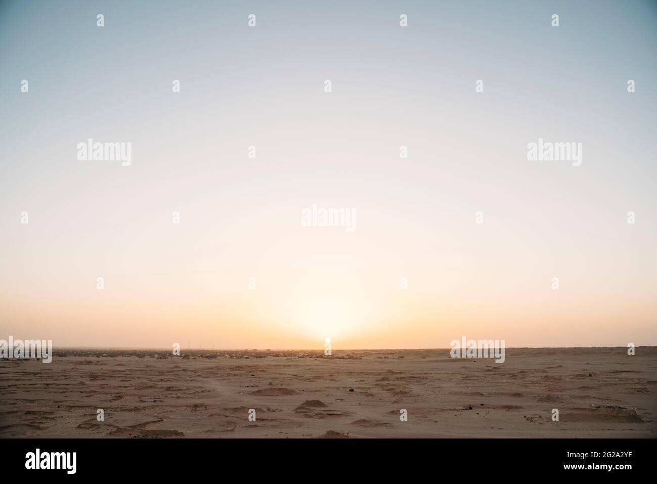 Amazing view of cloudless evening sky with setting sun over dry sand of ...