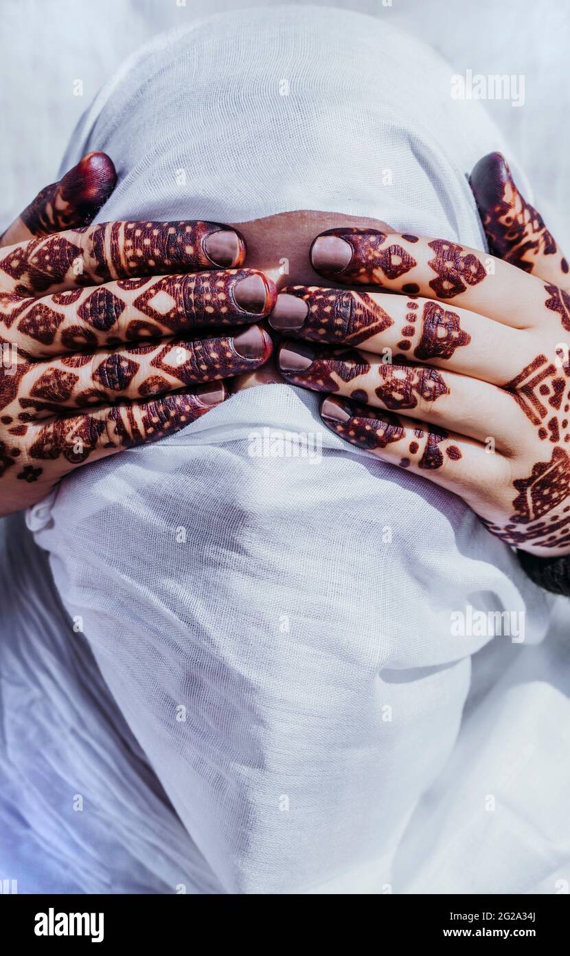Tattooed hands of unrecognizable Woman covering eyes of anonymous Arab ...