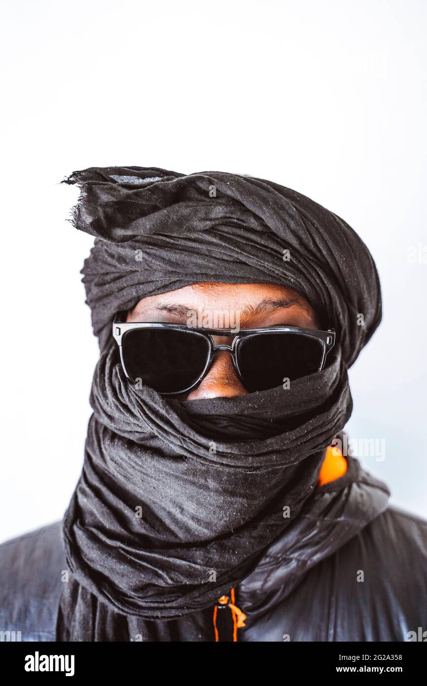 Anonymous African person in black keffiyeh and sunglasses while ...