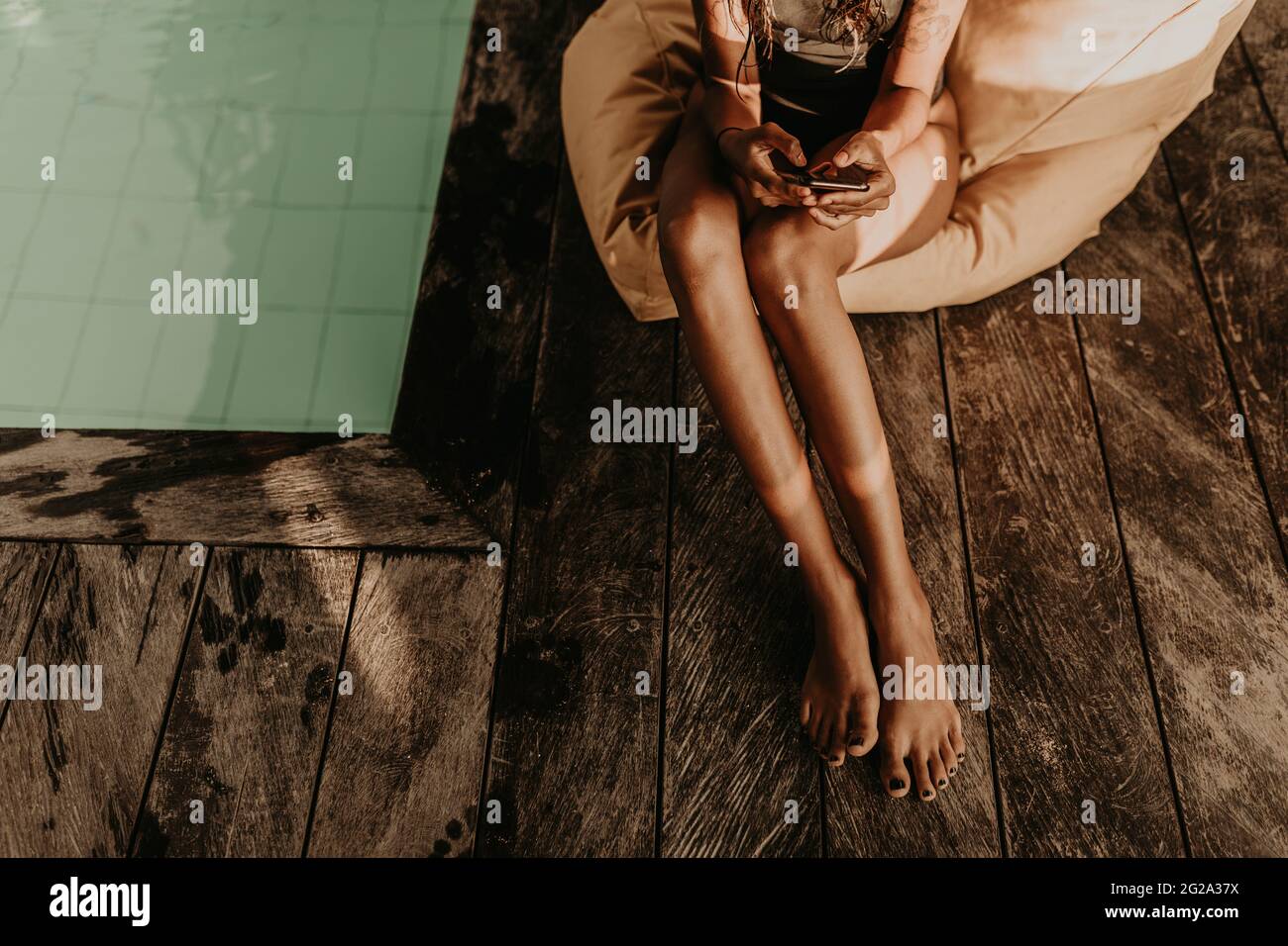 Woman sitting near pool using hi-res stock photography and images - Alamy