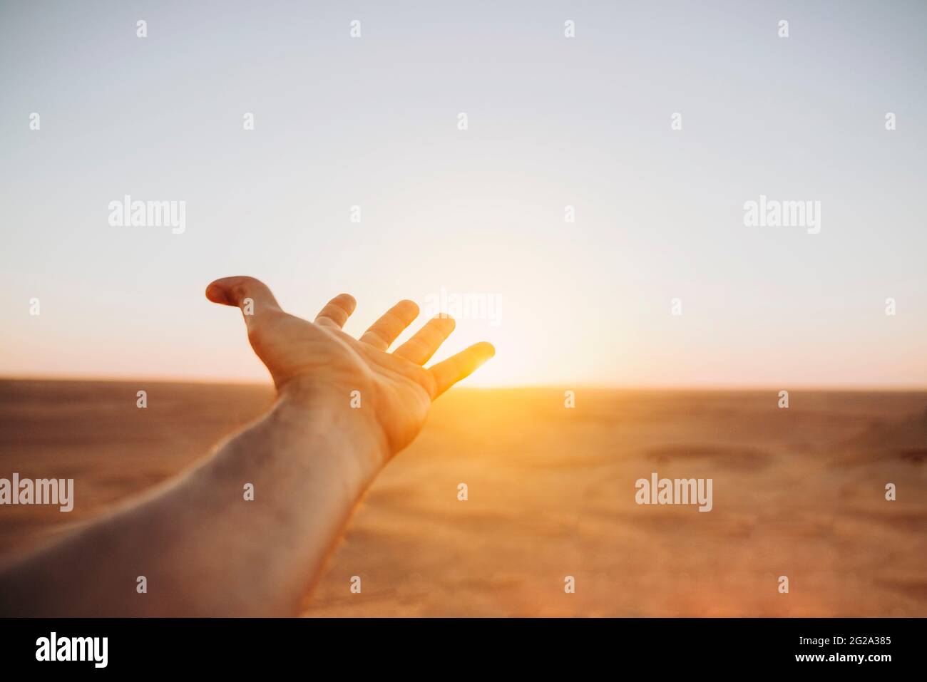 Open hand setting against the sunset sun in the Sahara desert Stock ...