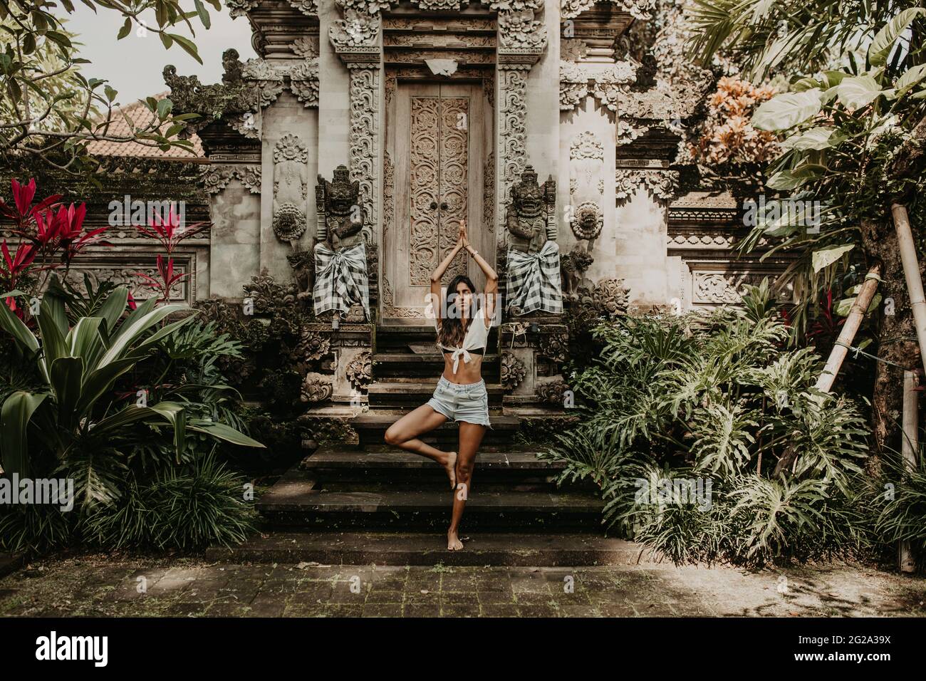 Attractive concentrated ethnic female doing yoga pose and meditating ...