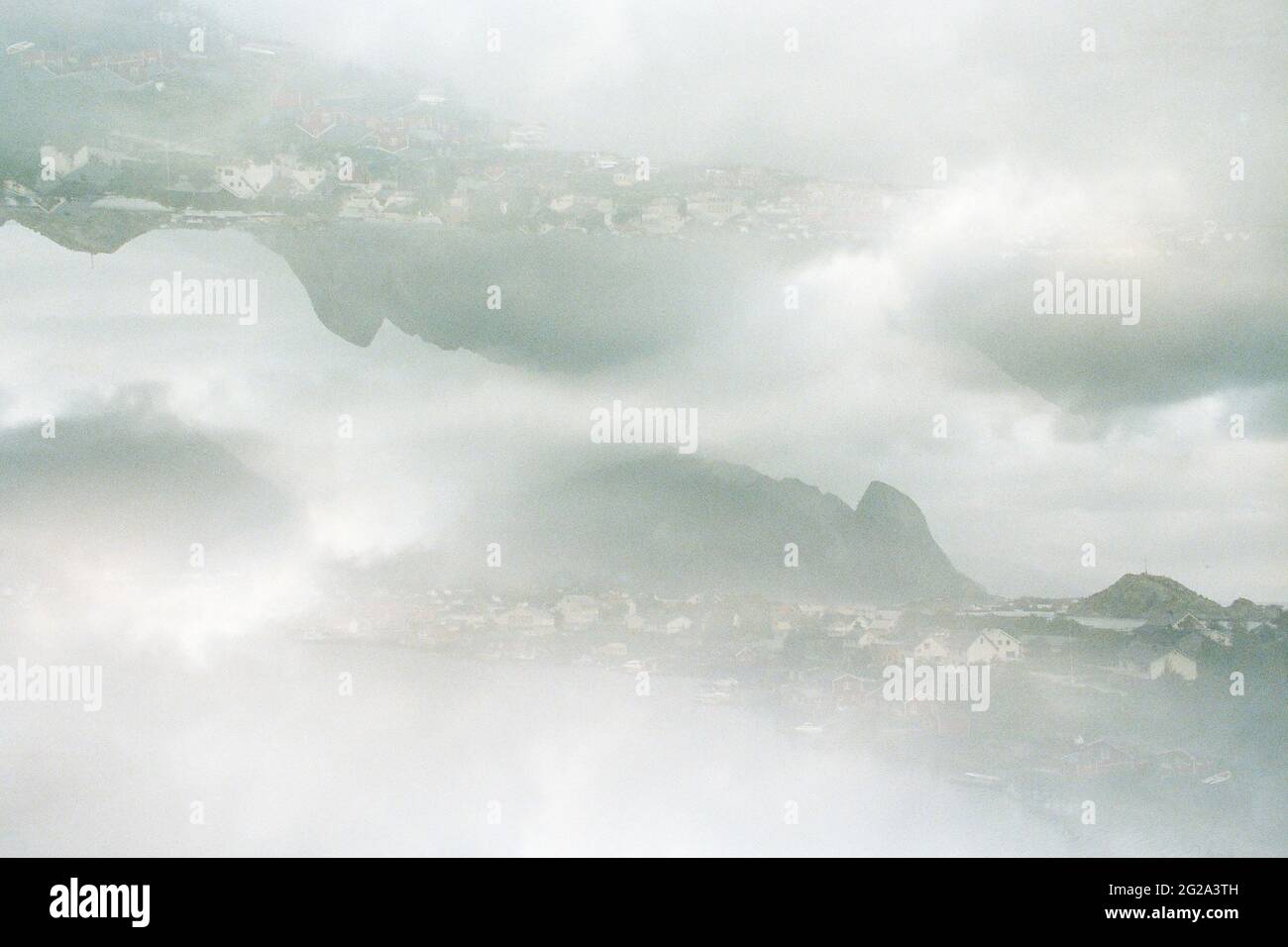 Thick clouds floating over mountain ridge and water surface in Lapland ...