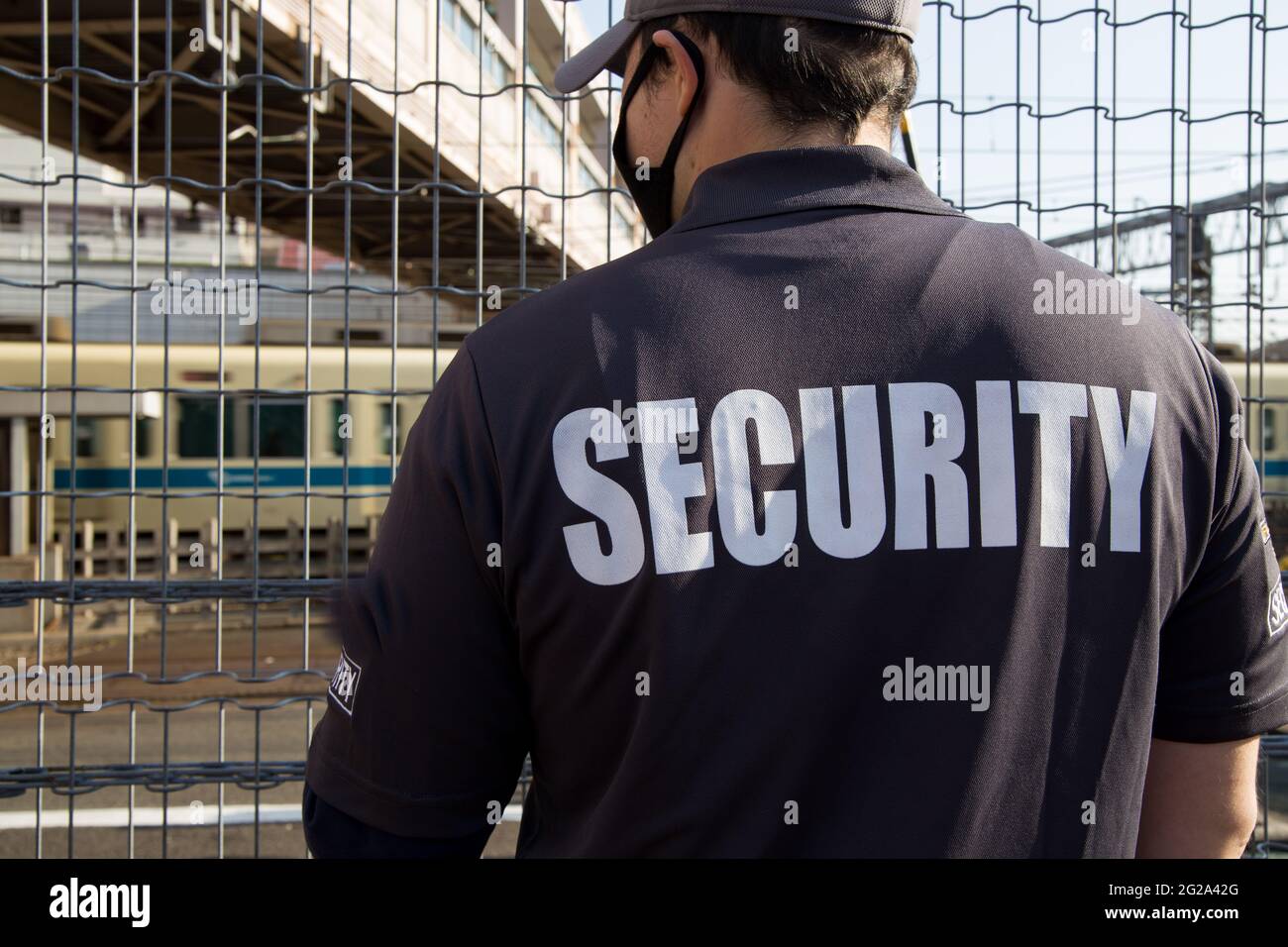 Back view of a security guard in uniform patrolling a residential area ...