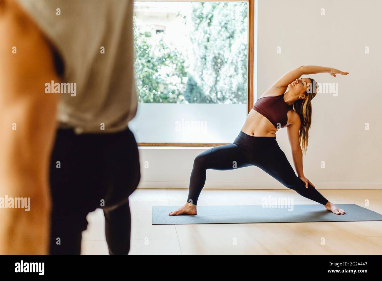 Group of young attractive people practicing yoga lesson in bright ...