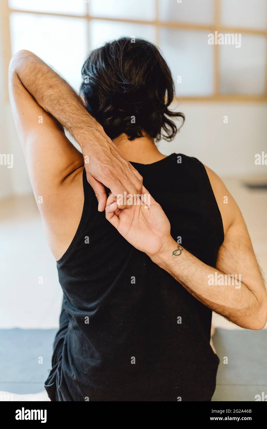 Side view of young slender man in sportive wear practicing yoga asana ...