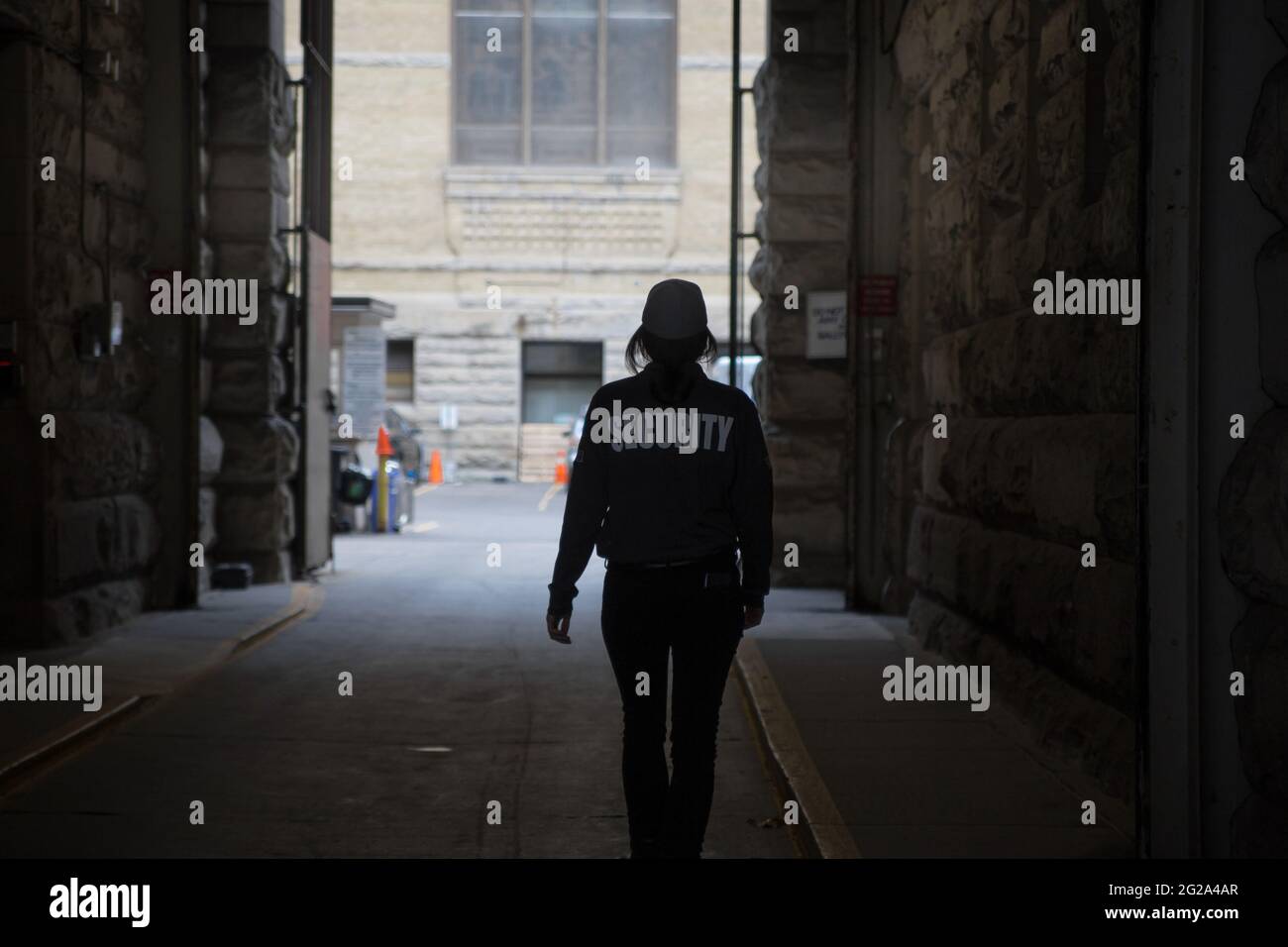 Back view of a security guard in uniform patrolling a residential area ...