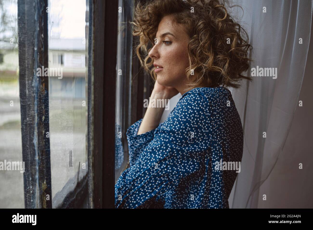 Side view of charming curly Woman touching face and thoughtfully ...